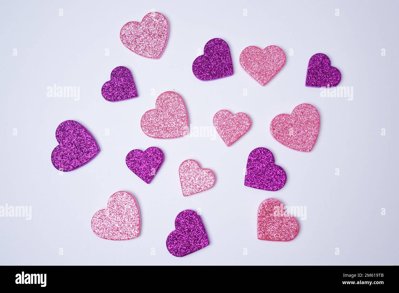 Glittering pink and lilac hearts on white background. Valentines day ...