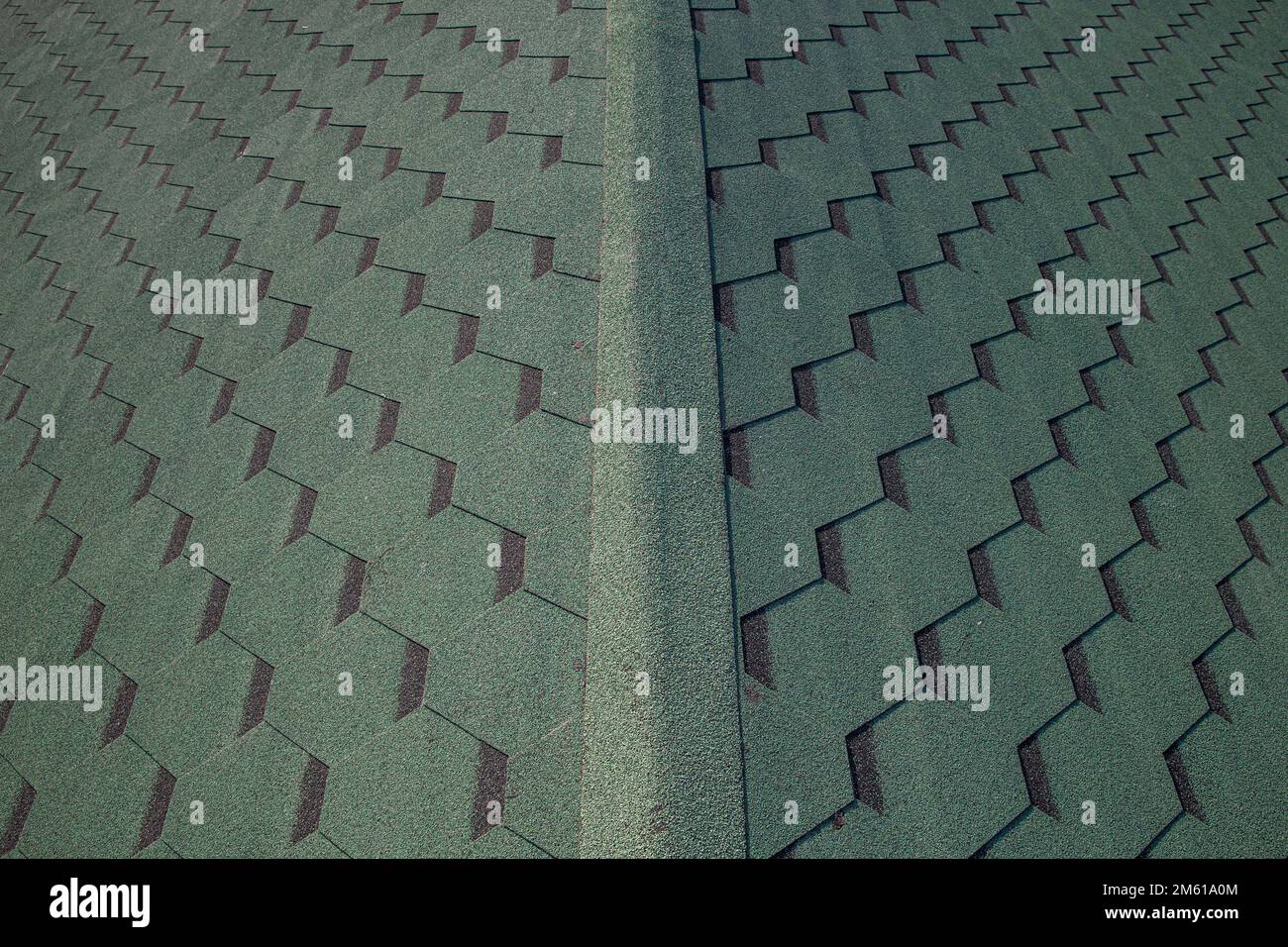 Roofing made of green soft bitumen tiles on a hipped roof of a house ...