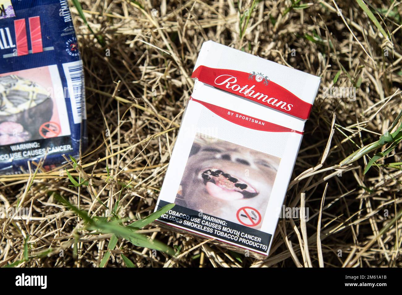 An empty packet of Rothmans Cigarettes with a health warning written ...