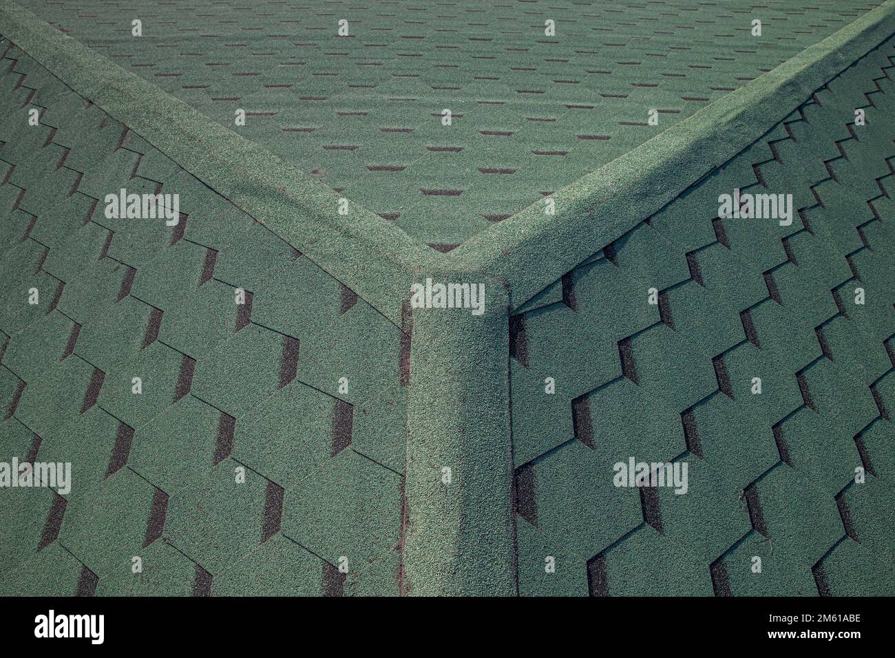 Roofing made of green soft bitumen tiles on a hipped roof of a house ...