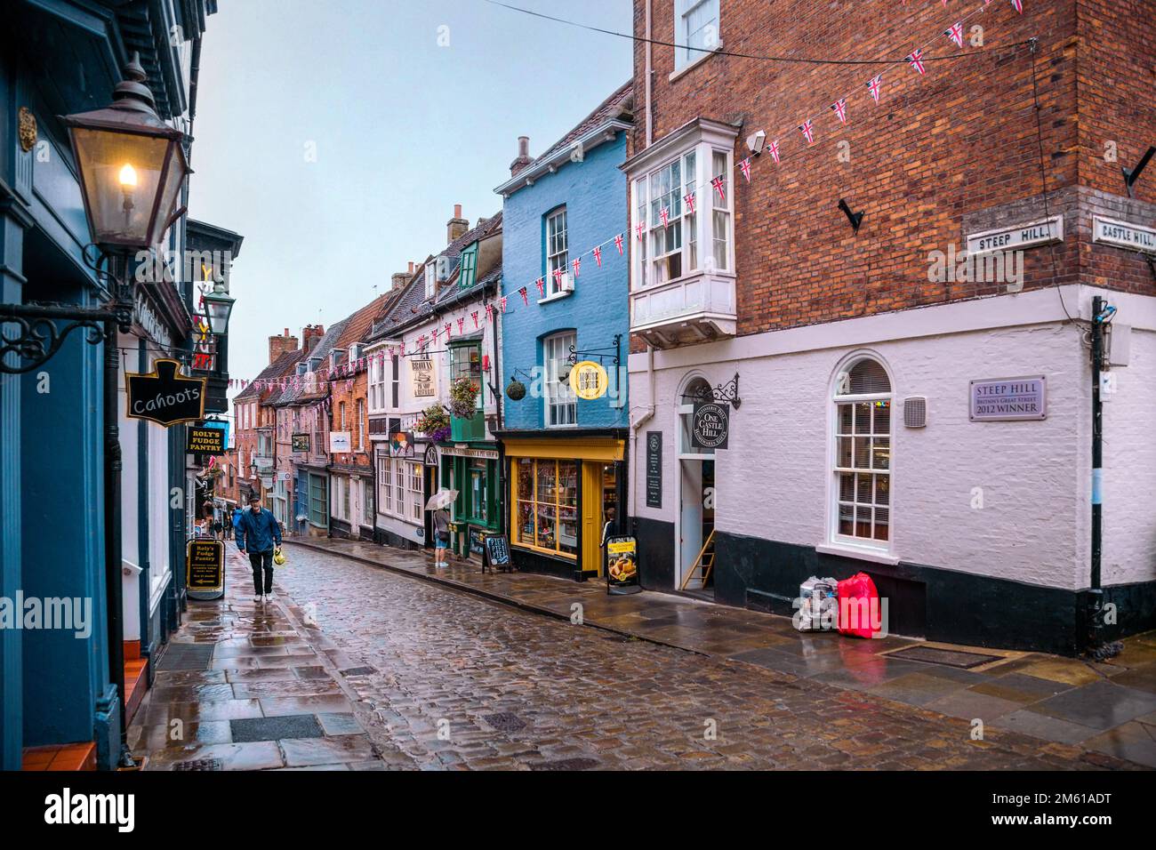 Quaint shops line a steep cobbled road known as Steep Hill in Lincoln ...