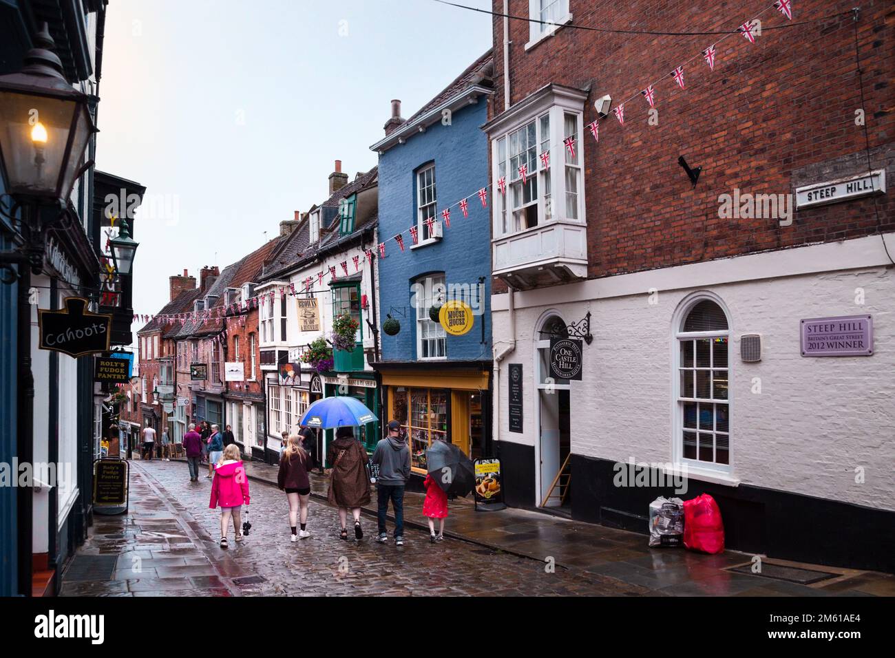 Quaint shops line a steep cobbled road known as Steep Hill in Lincoln ...