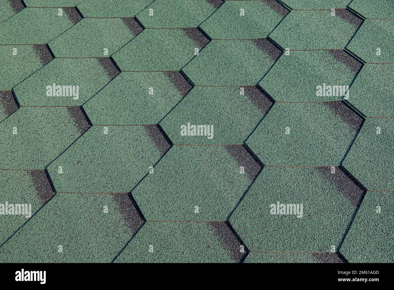 Roofing made of green soft bitumen tiles on a hipped roof of a house ...