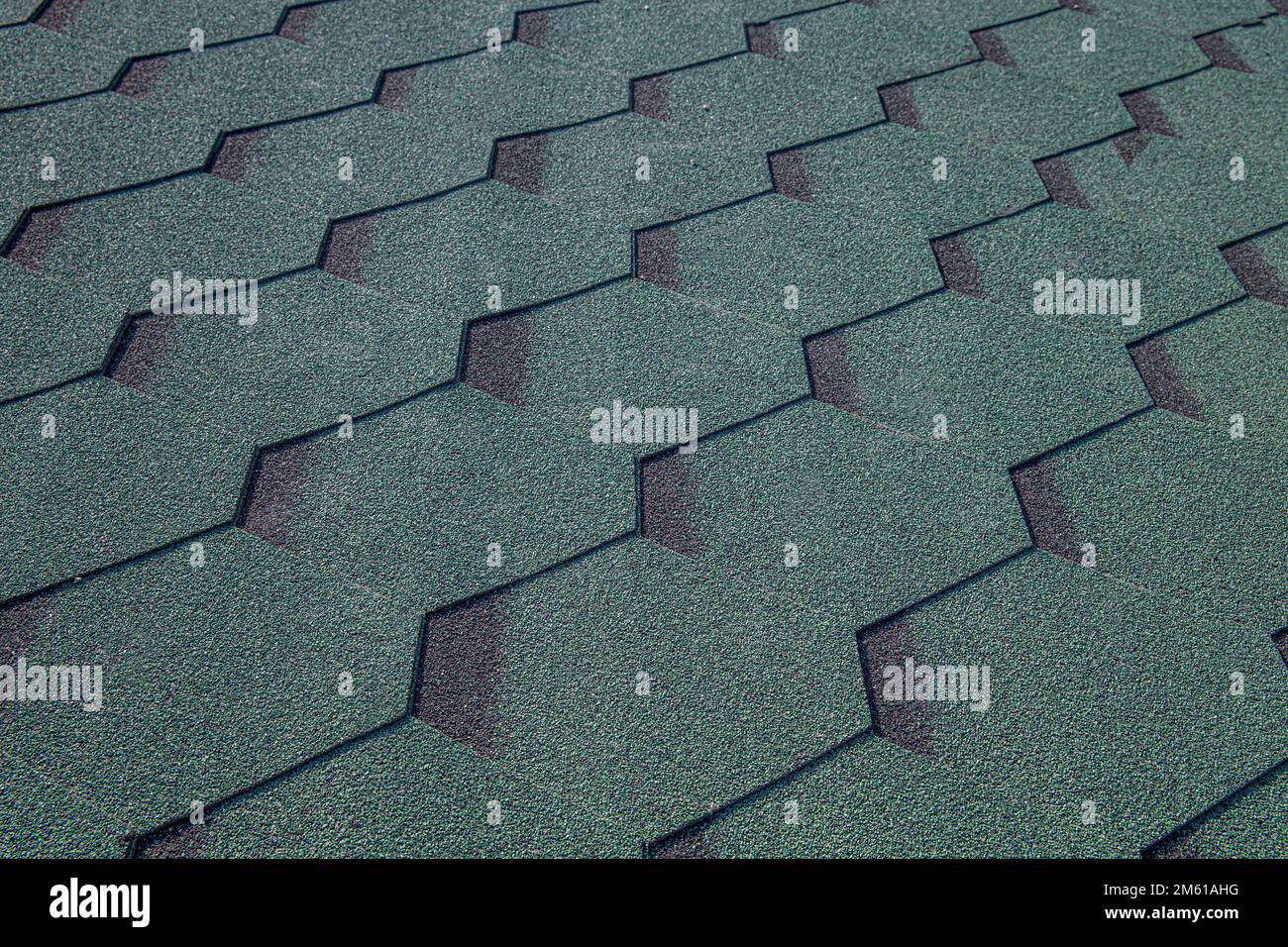 Roofing made of green soft bitumen tiles on a hipped roof of a house ...