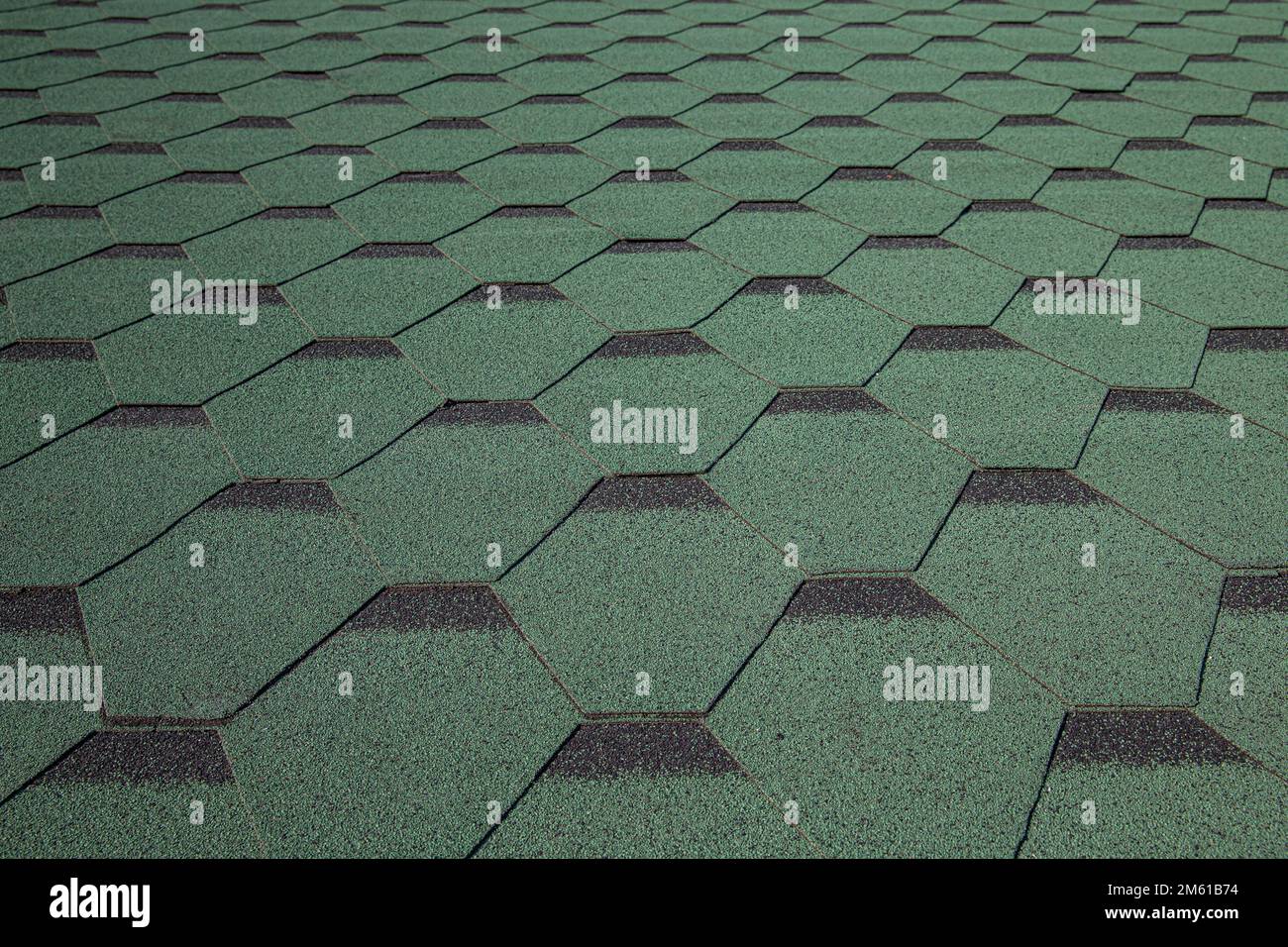 Roofing made of green soft bitumen tiles on a hipped roof of a house ...