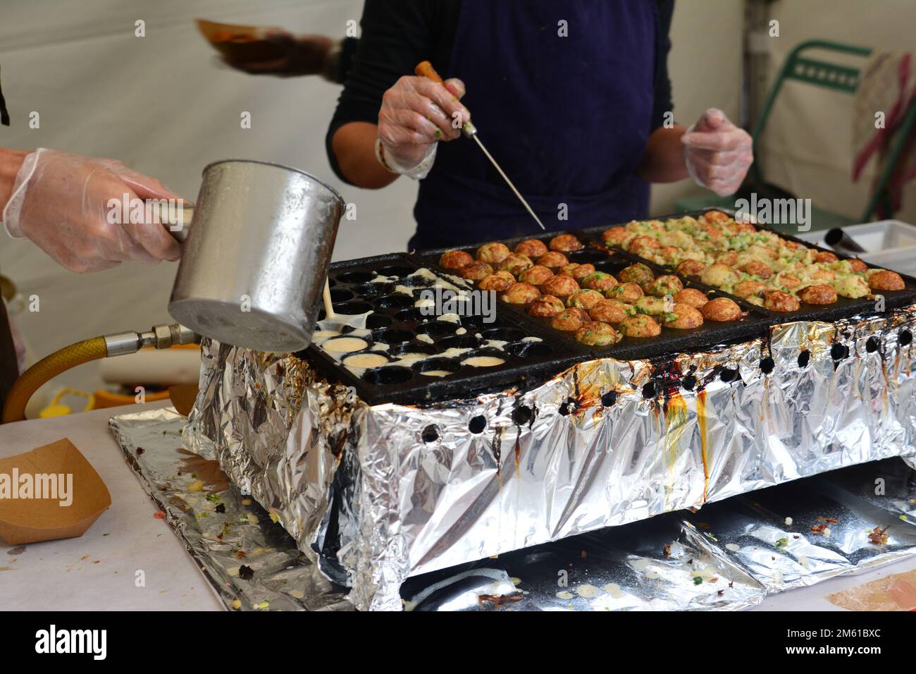 The cook pours a dough for Japanese fish balls Stock Photo - Alamy