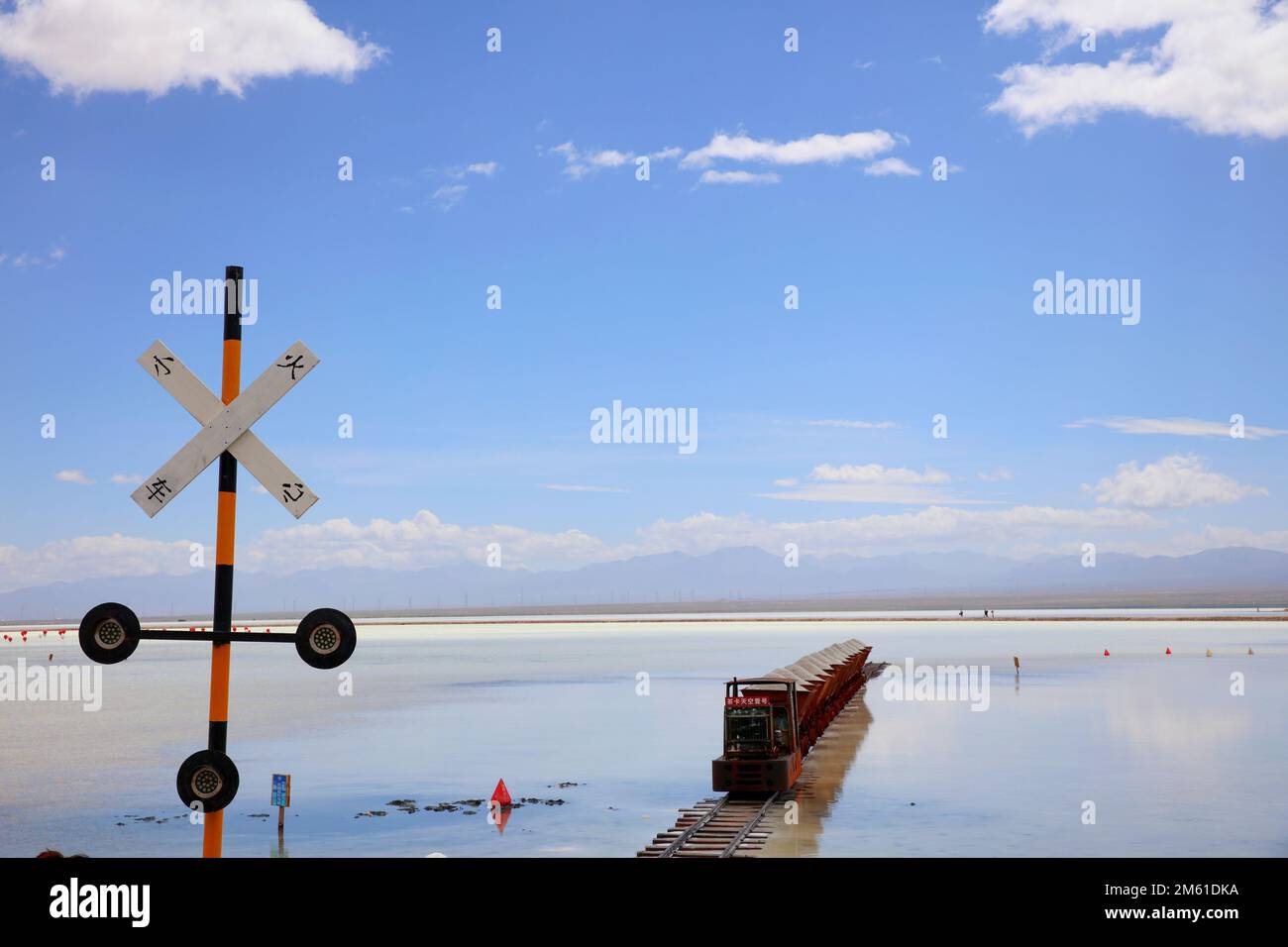 A railroad crossing sign with Chinese letters with an approaching train ...