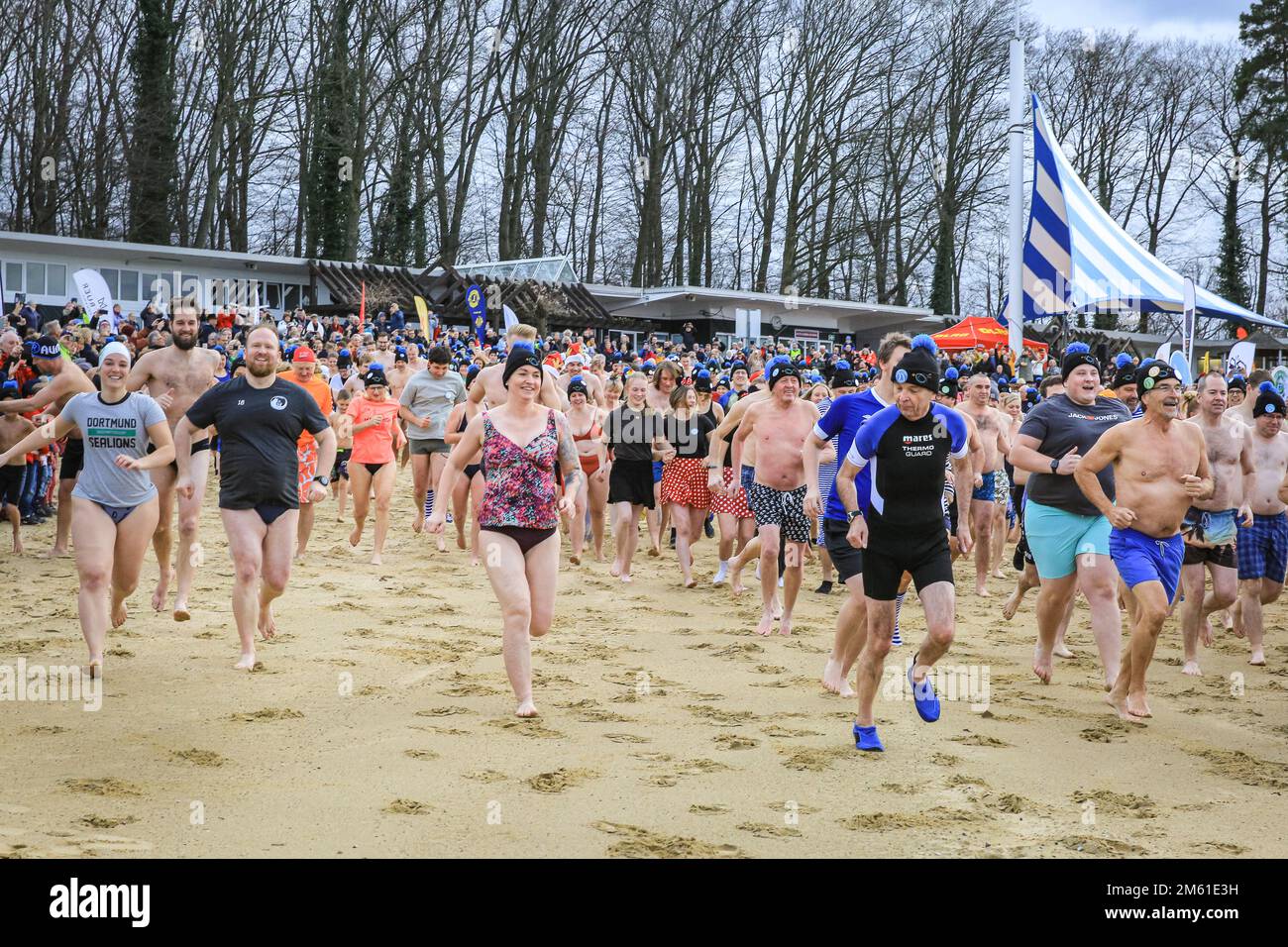 Haltern, Germany. 01st Jan, 2023. The swimmers race across the natural beach down to the water ...