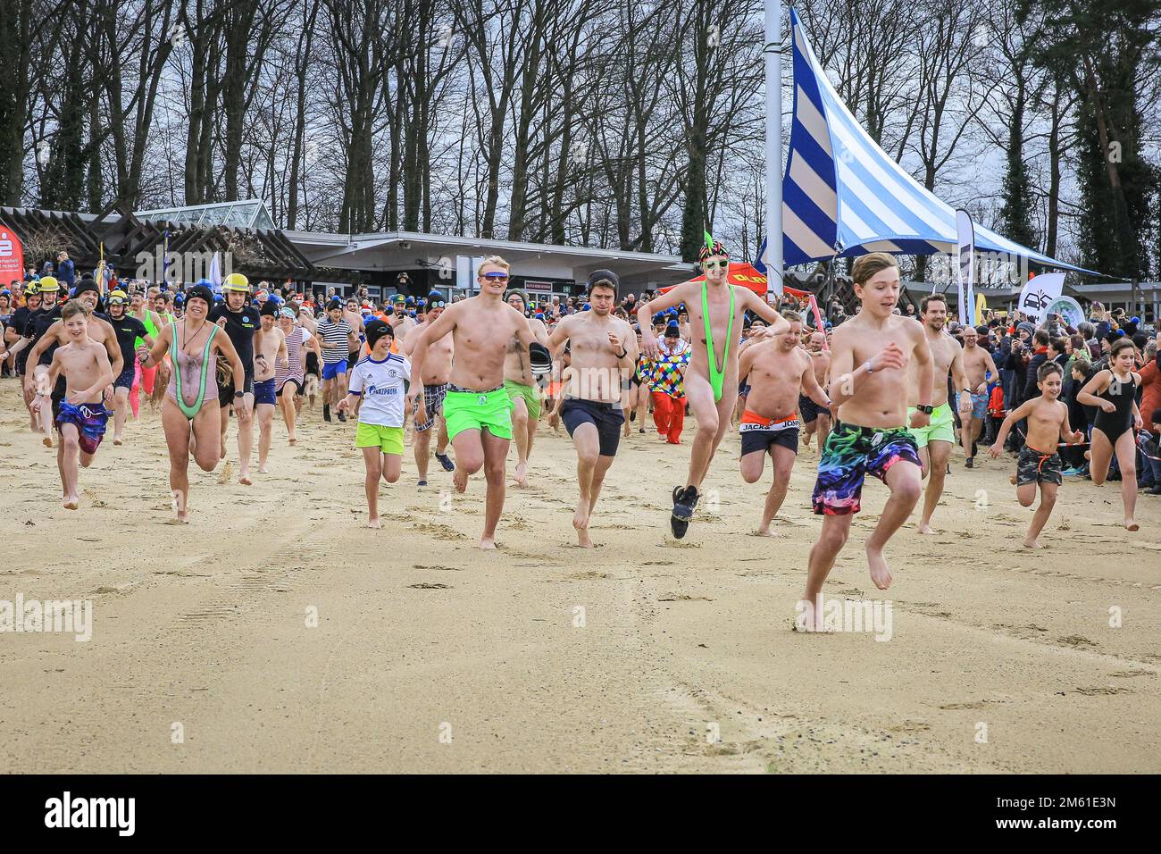 Haltern, Germany. 01st Jan, 2023. The swimmers race across the natural beach down to the water ...