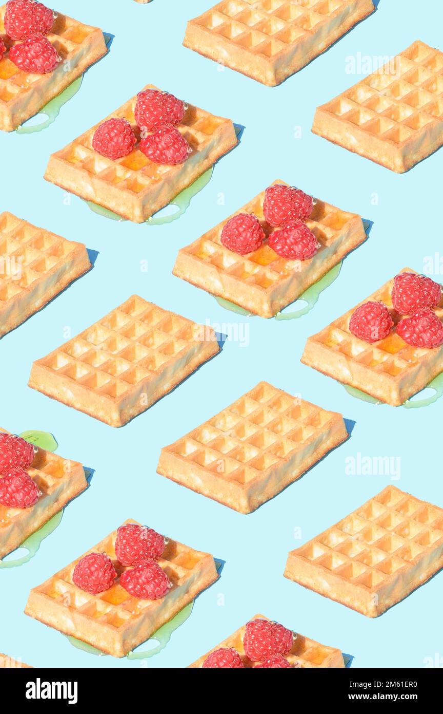 Fruit raspberry, honey and waffle arranged in a patern on a blue ...