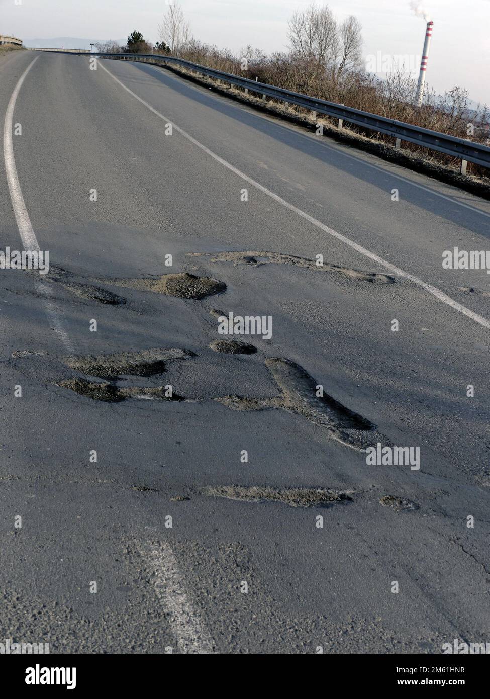 Lot of potholes on an asphalt road after winter Stock Photo - Alamy