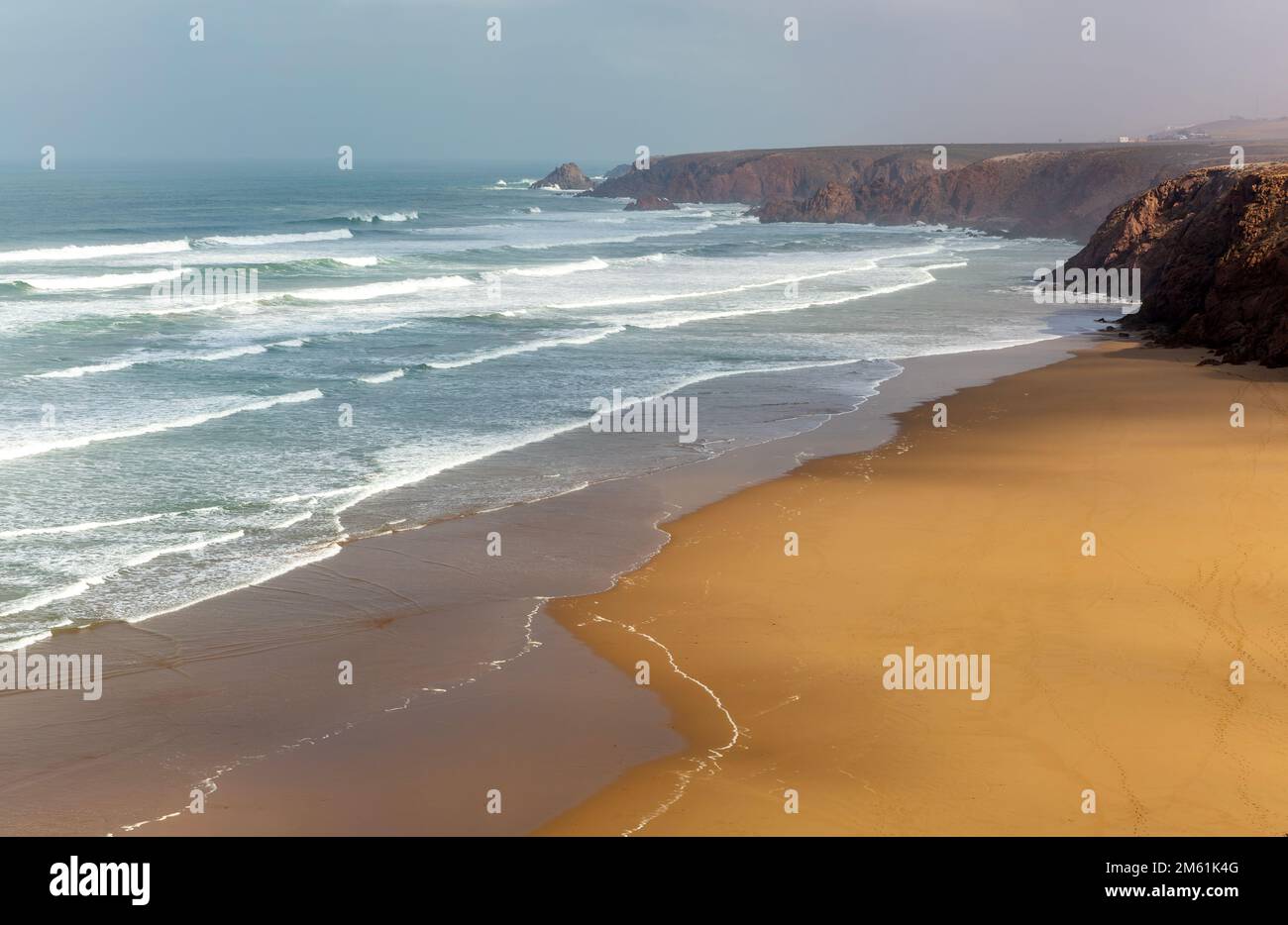 Waves breaking coastal cliffs and sandy beach, Plage Imin Turga ...
