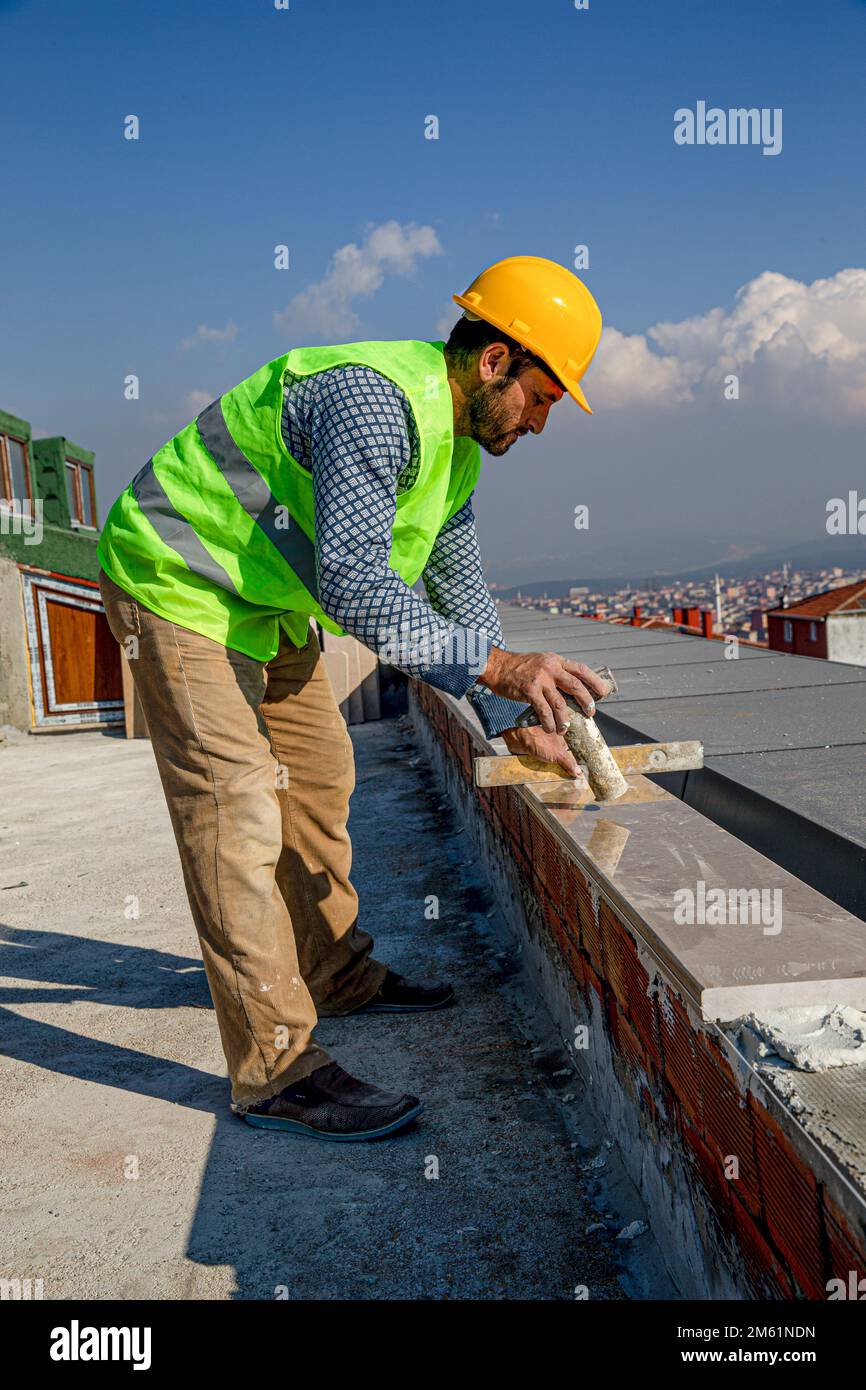 The builder is hitting the marble with a hammer and leveling it with a ...