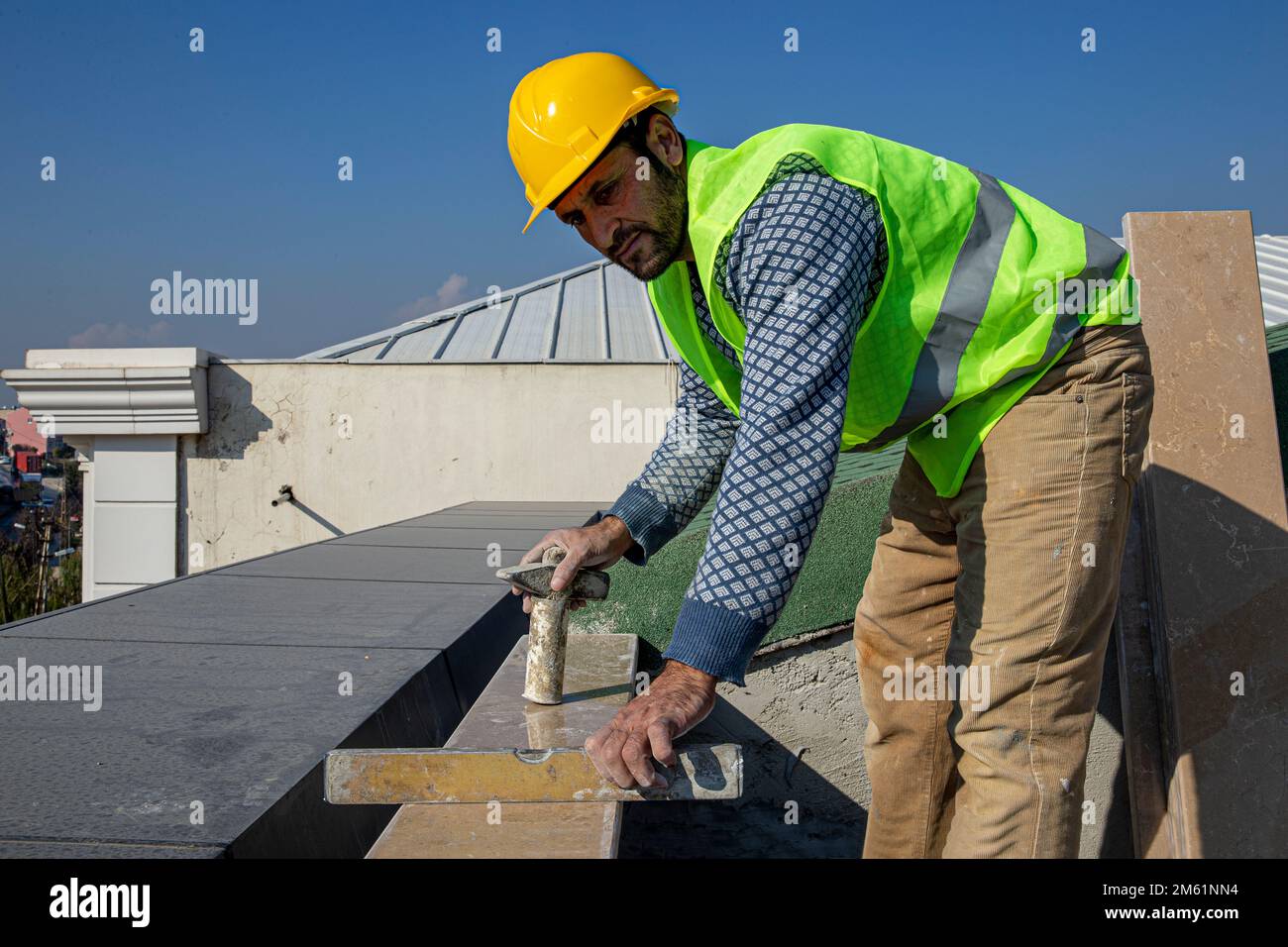 The builder is hitting the marble with a hammer and leveling it with a ...