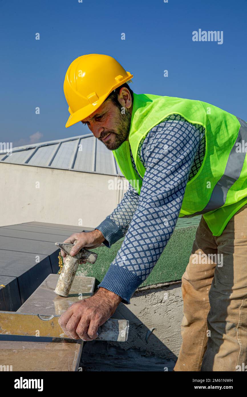 The builder is hitting the marble with a hammer and leveling it with a ...