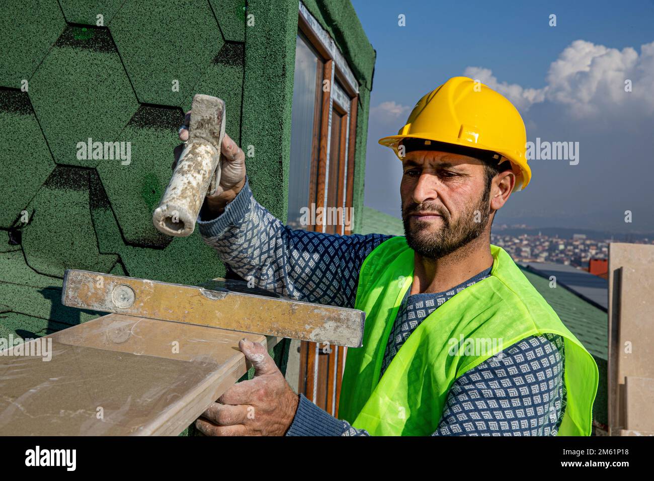 The builder is hitting the marble with a hammer and leveling it with a ...
