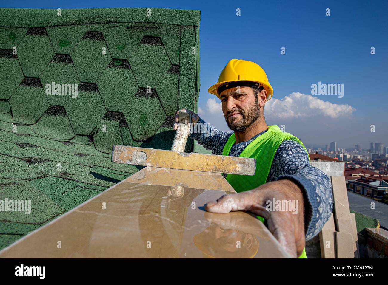 The builder is hitting the marble with a hammer and leveling it with a ...