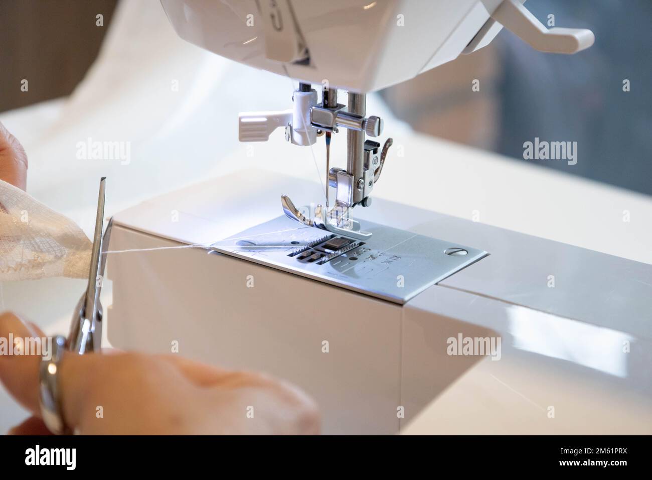 Close up top side view of cropped female hands sewing fabric in ...