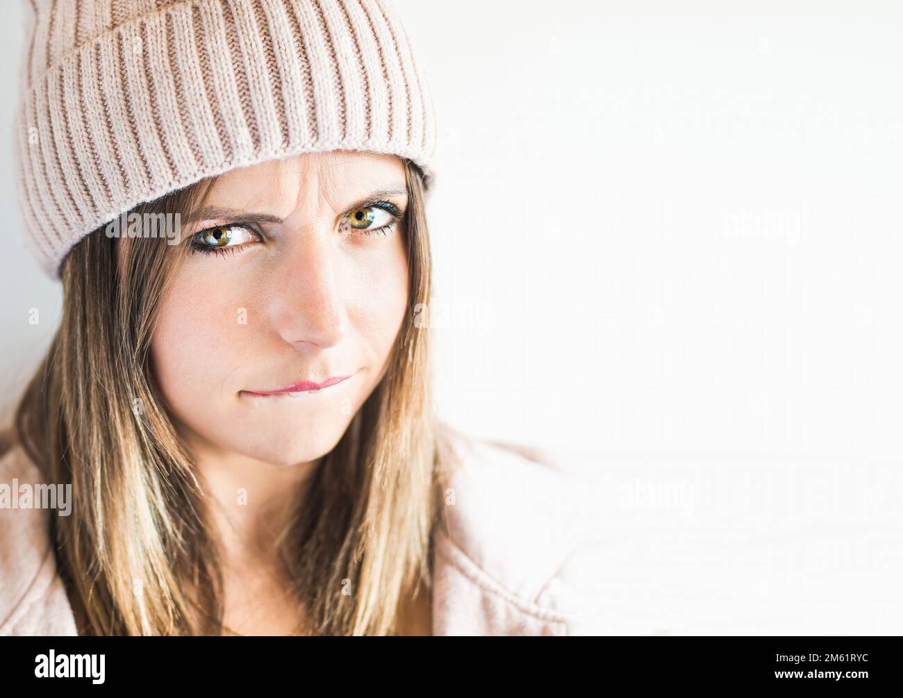 Close-up of a Caucasian woman wearing a cap, looking with an angry ...