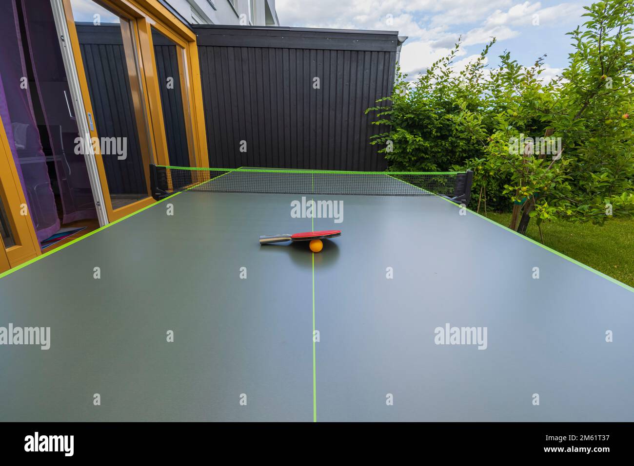 View of tennis ping pong table with net and racket with orange ball in ...