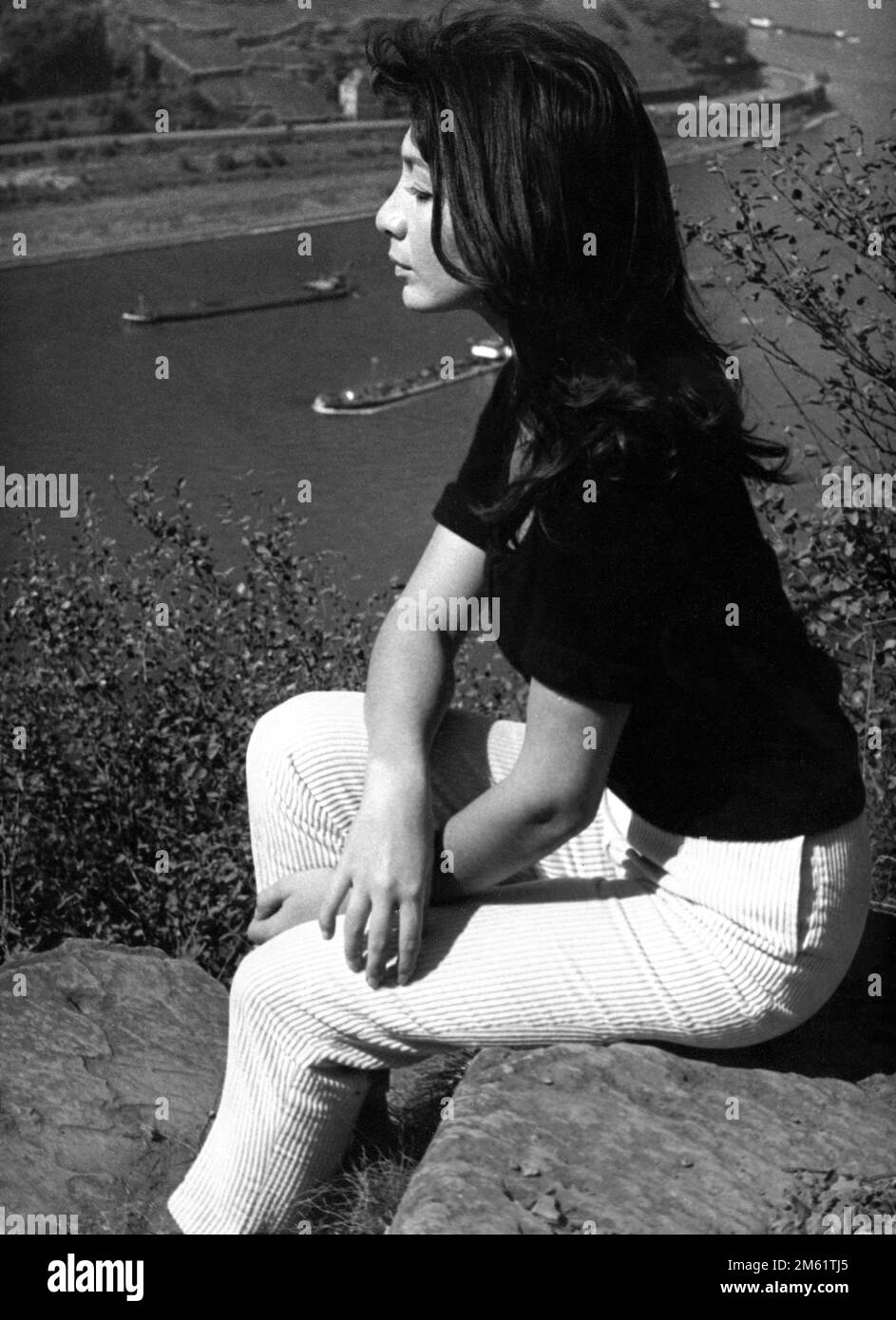 JULIETTE GRECO candid portrait sitting on the Lorelei rock above the ...