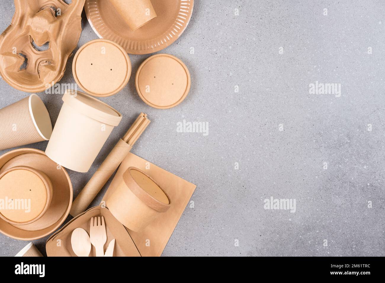 Various paper utensils around over gray concrete background with copy ...