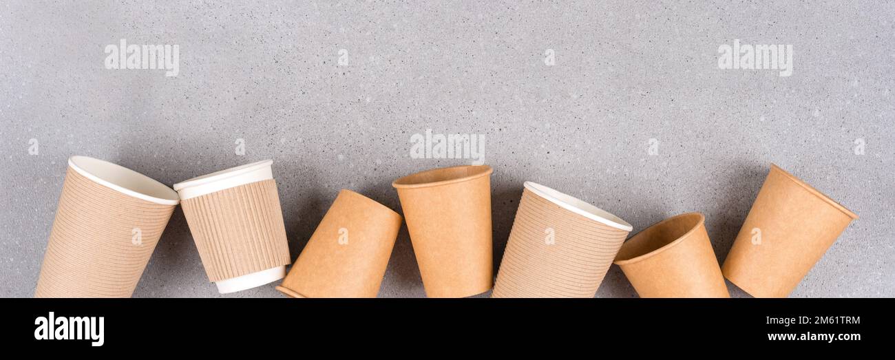 Banner with many paper coffee cups over gray concrete background with ...