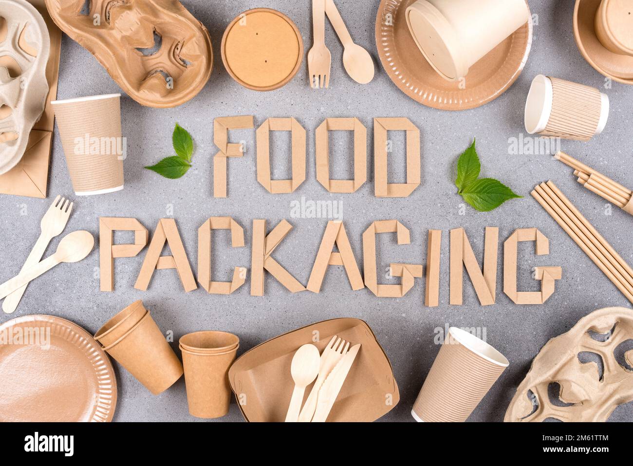 Text FOOD PACKAGING with various paper utensils around over gray ...