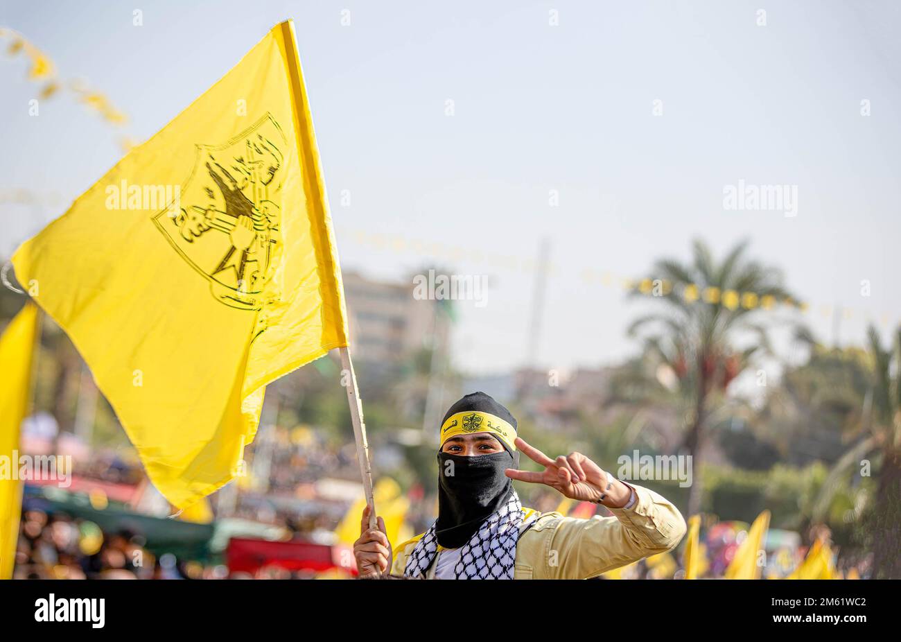 A Palestinian waves a yellow flag, during a festival commemorating the ...