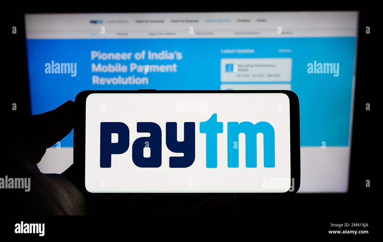 Person holding cellphone with logo of Indian digital payments company Paytm on screen in front ...