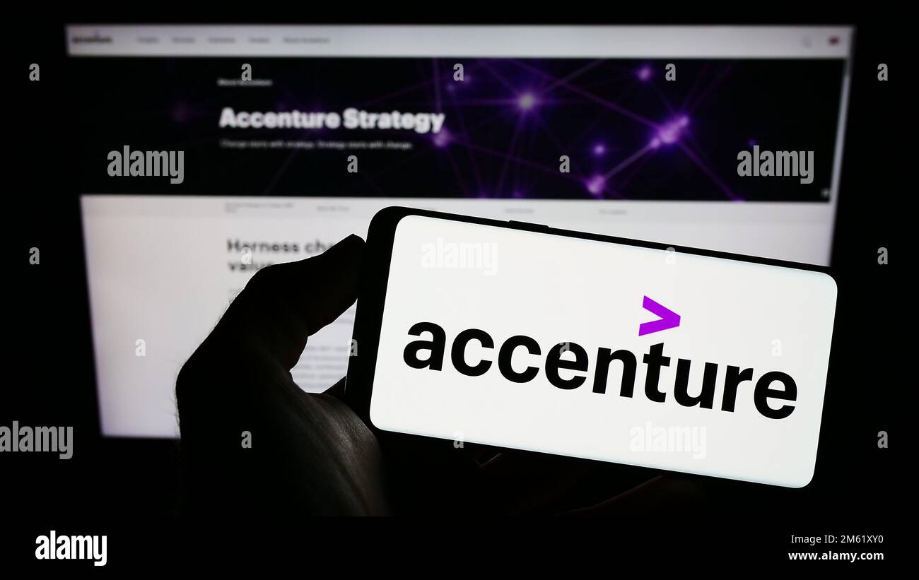 Person holding smartphone with logo of information technology company ...