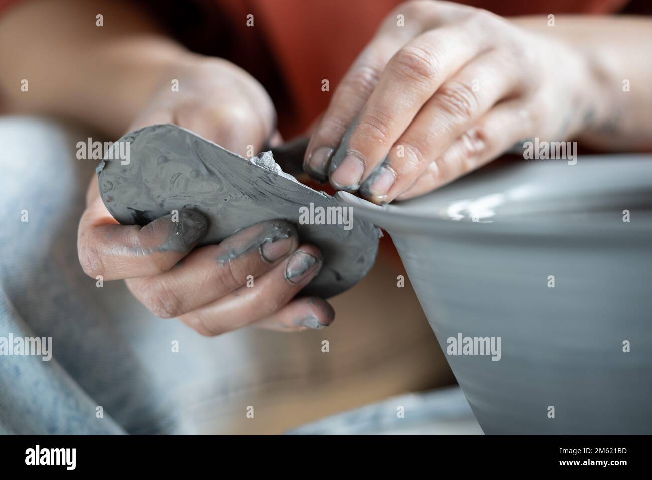 Ceramist using metal rib for pottery shaping, potter working with clay ...