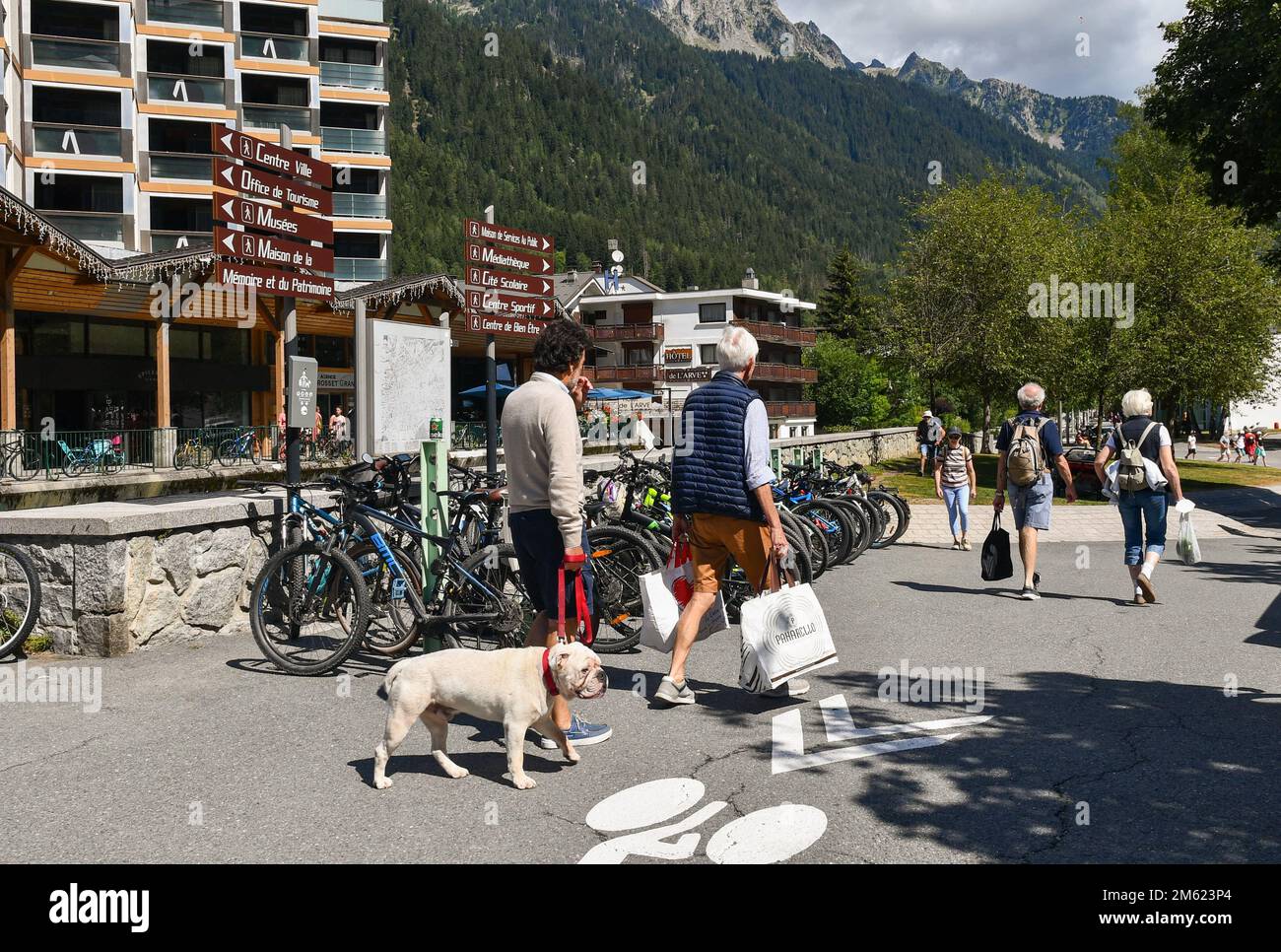 People walking on the riverside promenade with parked bikes and the Red ...
