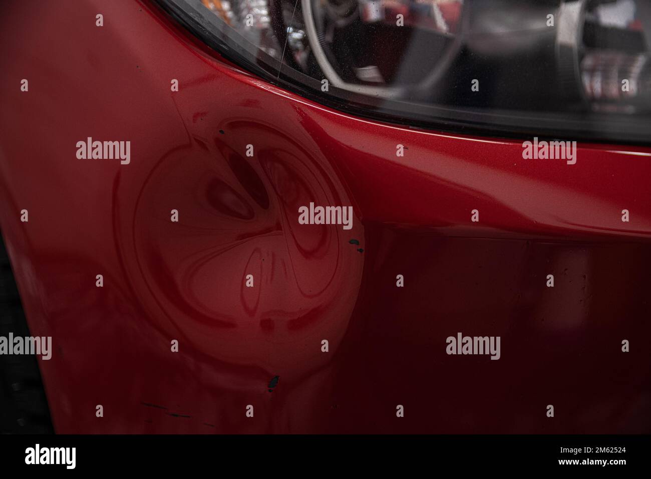Dent on the bumper of a red car for repair Stock Photo - Alamy