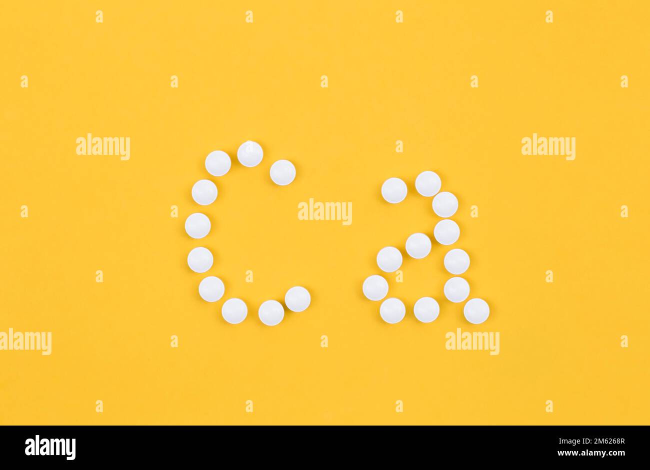 Flat lay composition with calcium supplement pills on yellow background ...