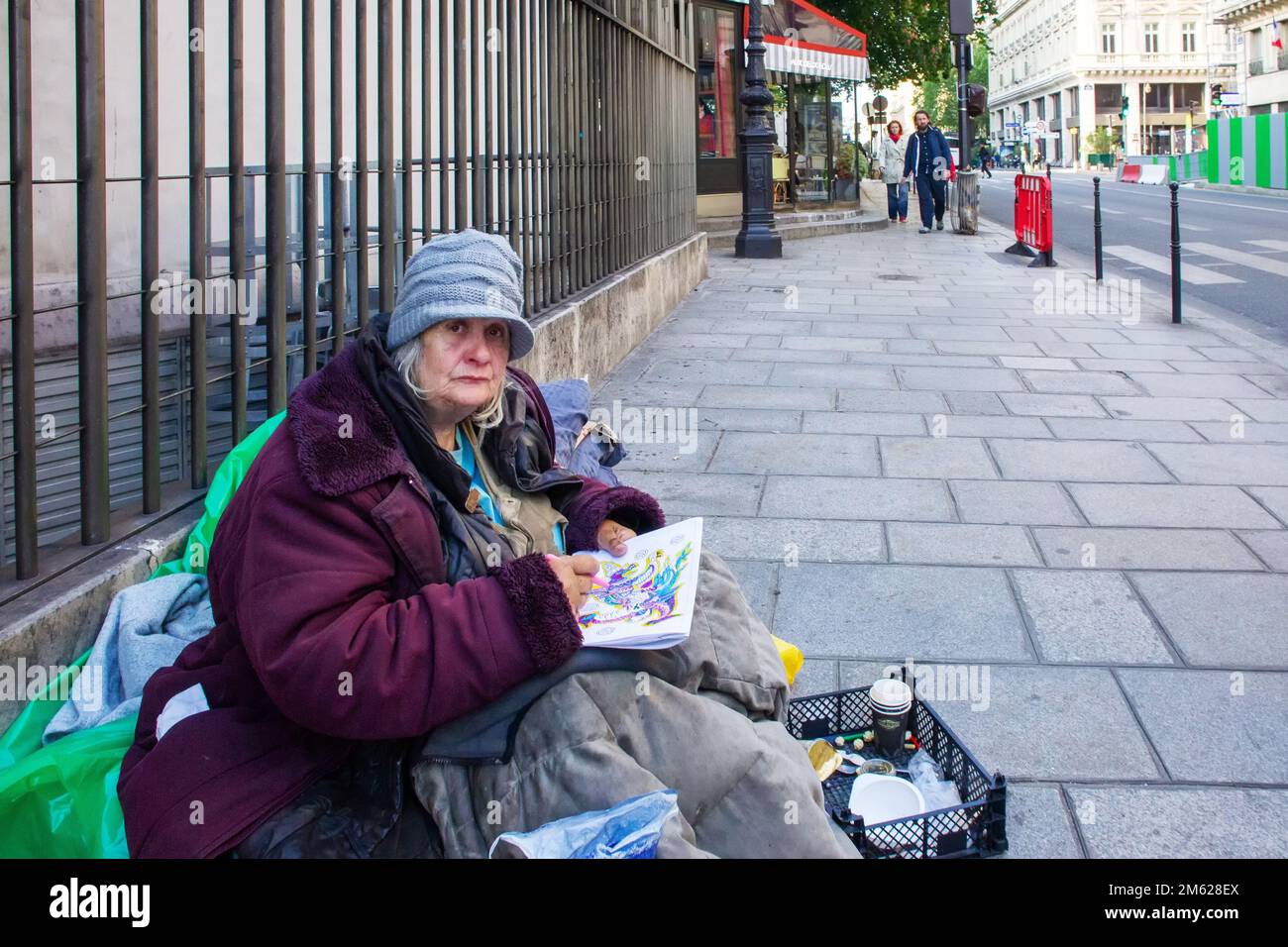 05-15-2016 Paris France. An old woman (homeless) draws with a pen on a ...