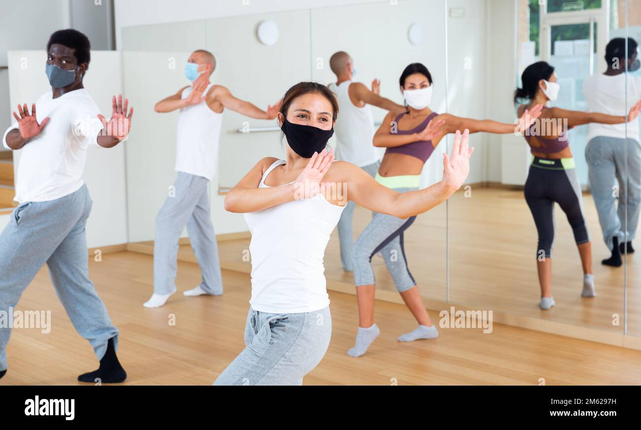 People in protective masks learning swing steps at dance class Stock ...