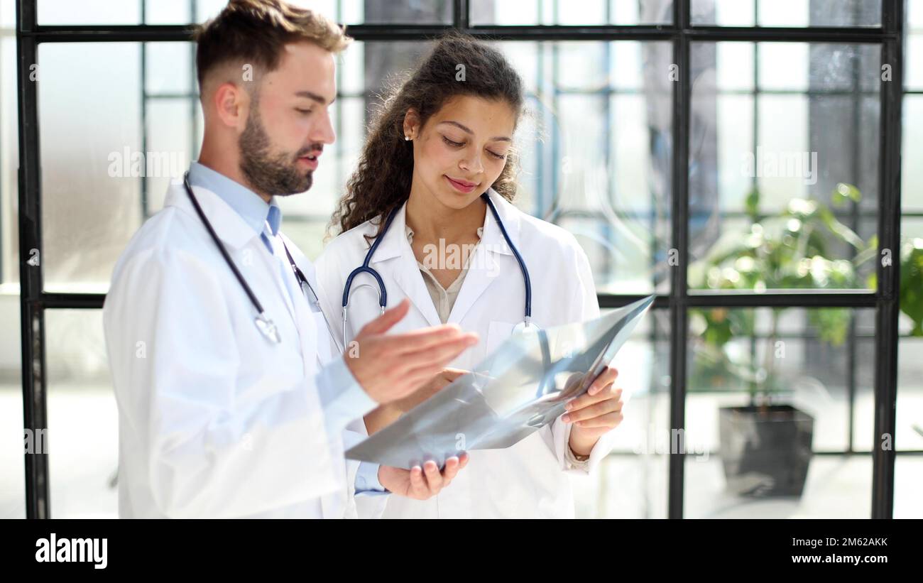 Two busy doctors working with papers and xray images Stock Photo - Alamy