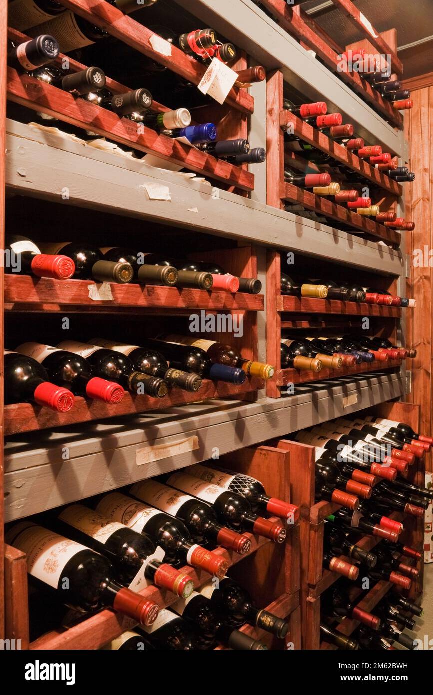 A collection of wine bottles in wine cellar inside old 1920s cottage ...
