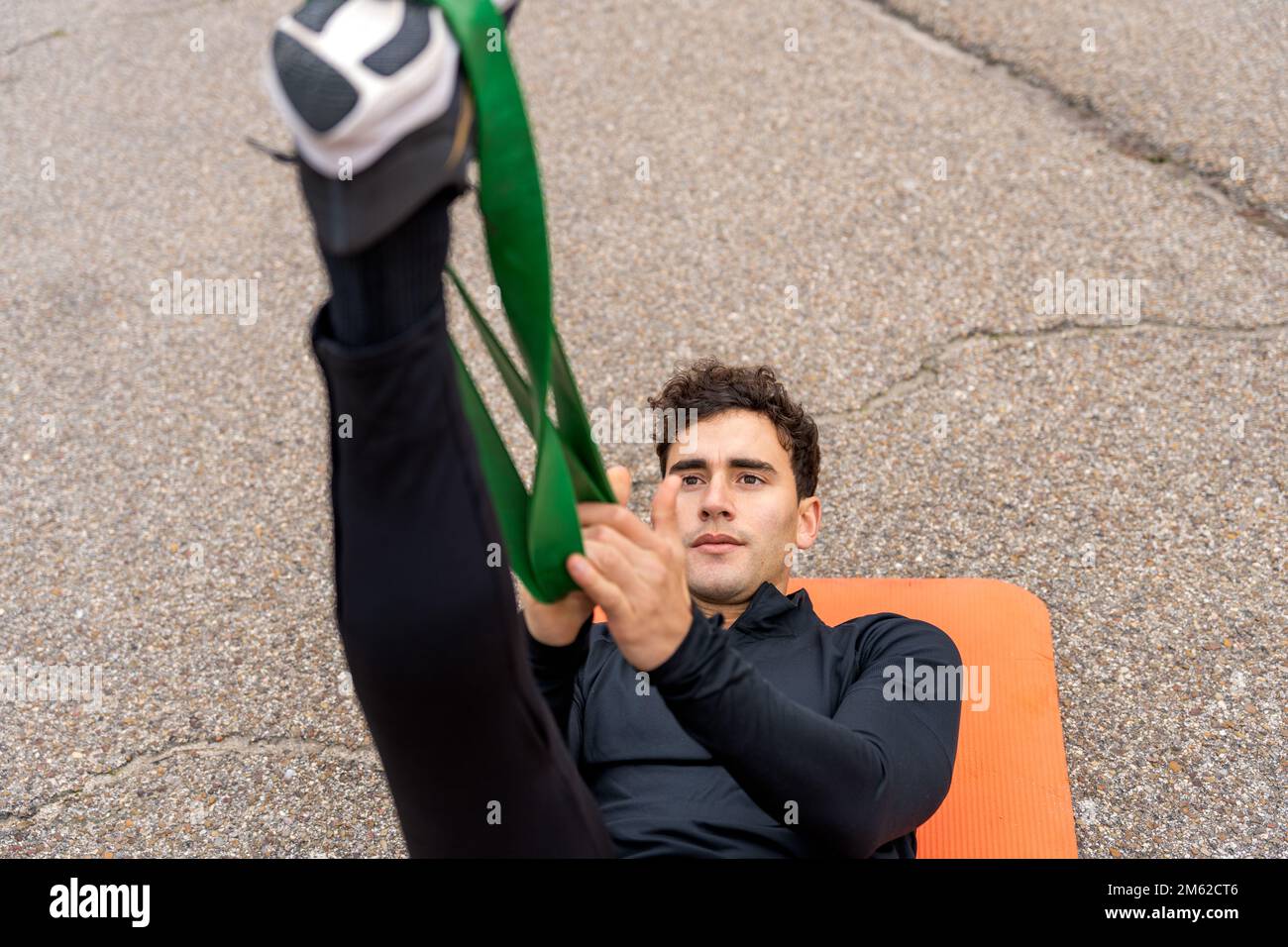 From above of focused young male lying on asphalt pavement and ...