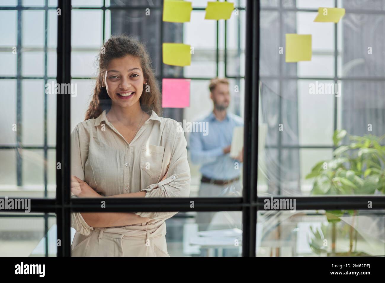 Smiling business woman looking out the window Stock Photo - Alamy