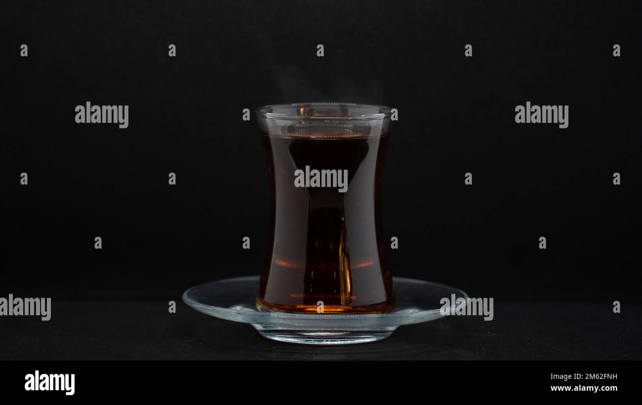 glass of turkish and arabic tea with a cup of coffee on a black ...