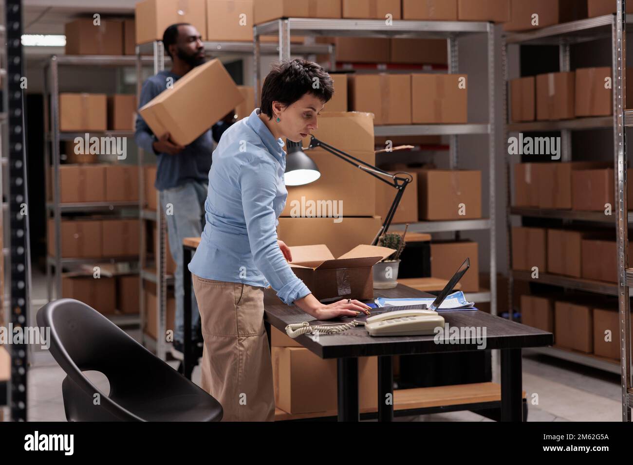 Woman employee preparing clients orders putting trendy clothes in ...
