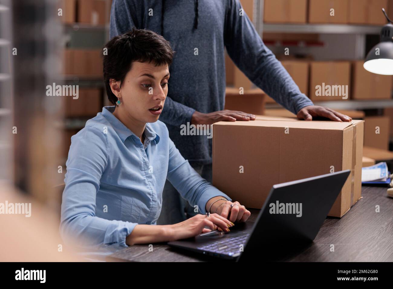 African american worker holding carton box while supervisor checking ...
