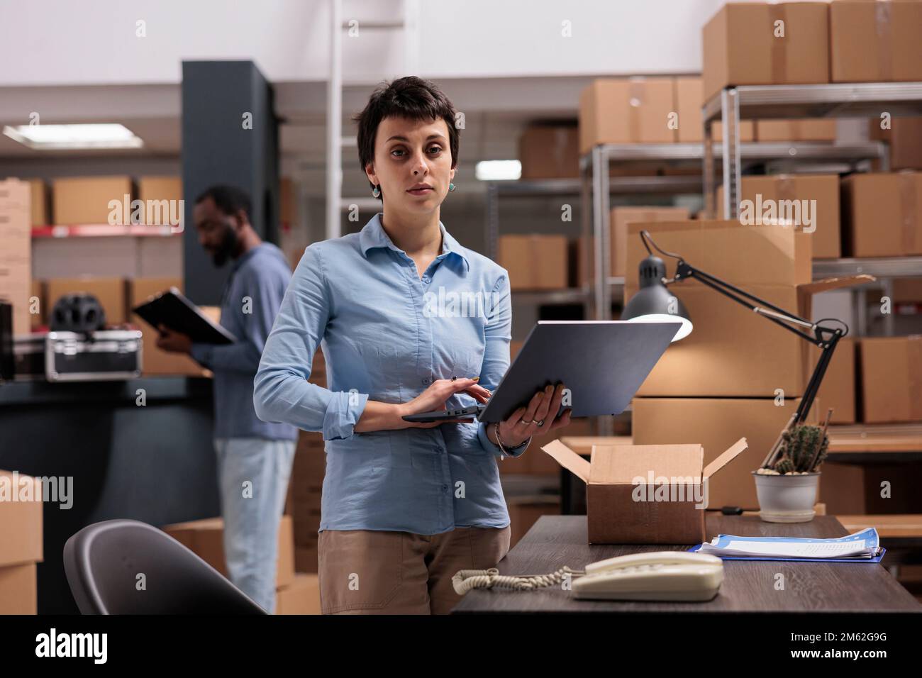 Warehouse supervisor holding laptop checking shipping detalies while ... Warehouse supervisor holding laptop checking shipping detalies while ...