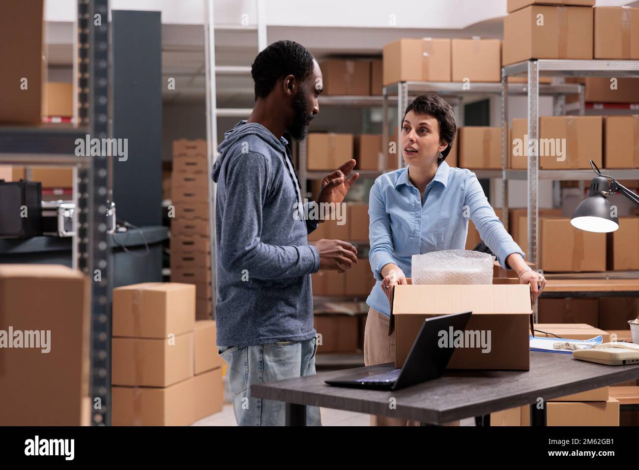 Warehouse team discussing about distribution logistics while putting ...