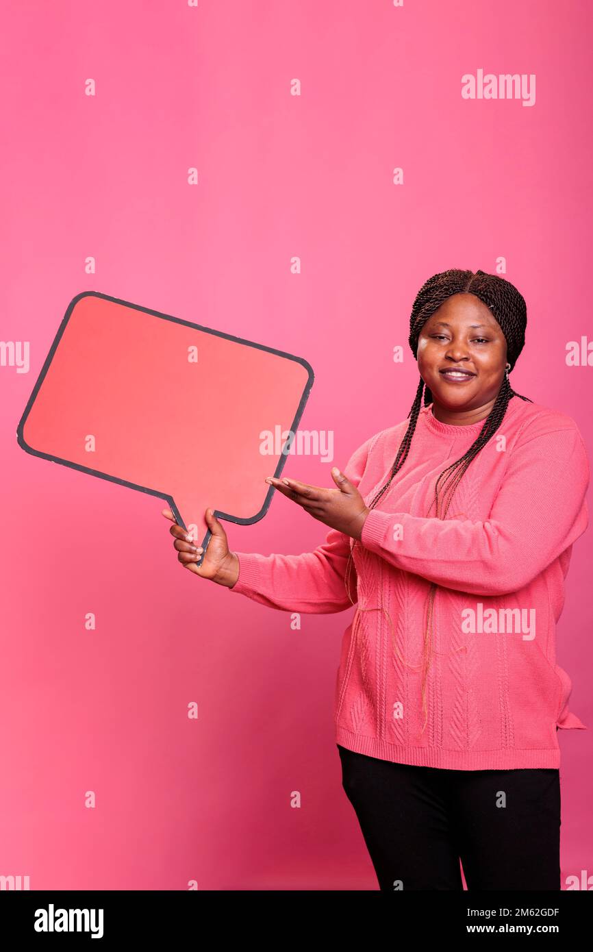 Joyful smiling adult woman holding blank template announcement placard ...