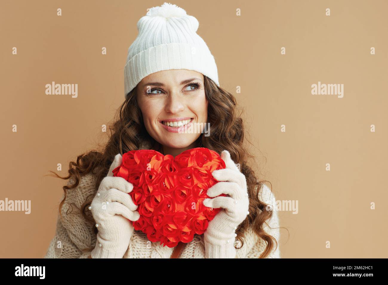 Hello winter. smiling modern woman in beige sweater, mittens and hat on ...