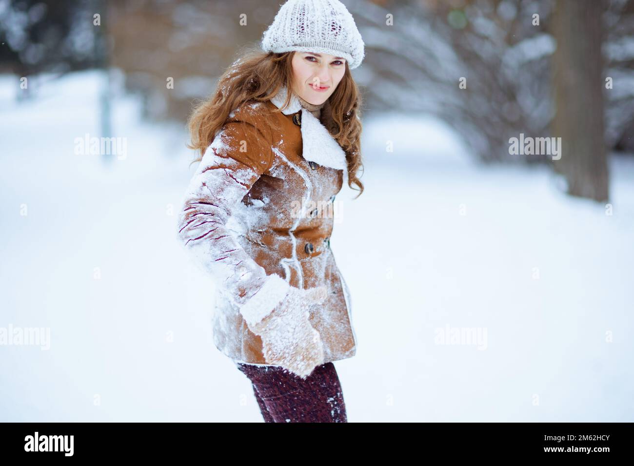 unhappy elegant 40 years old woman in brown hat and scarf in sheepskin ...