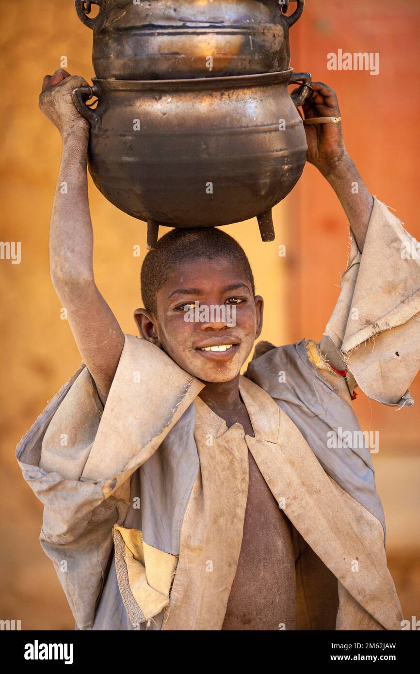 Young boy carrying pots on his head.in Niafunke ,Mali, West Africa ...